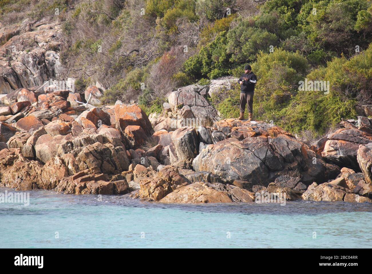 Man fishing from rocks at Ocean beach Western Australia Stock Photo - Alamy