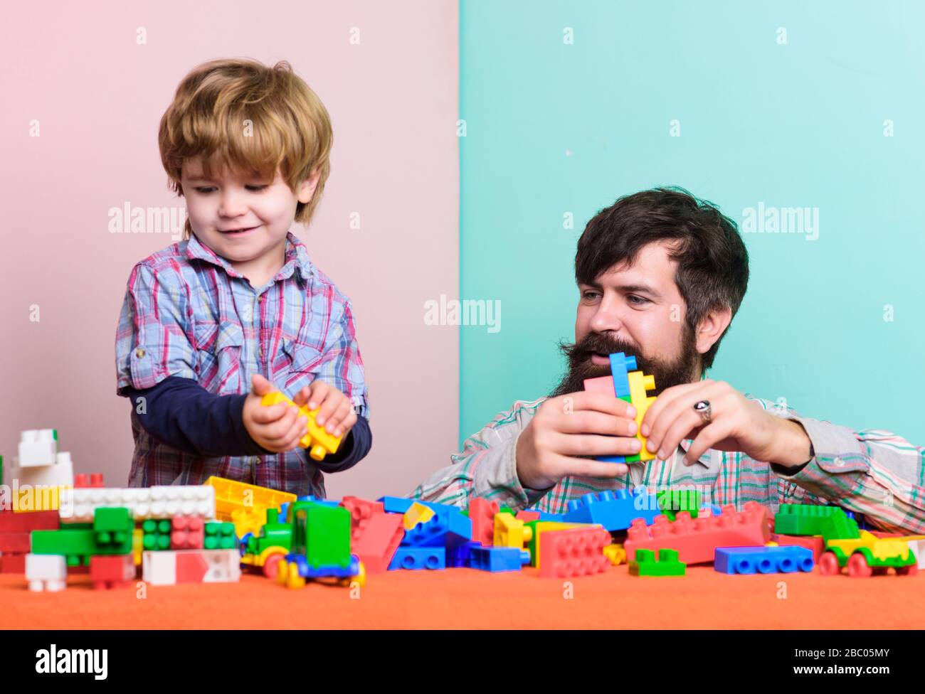 Dad and kid build of plastic blocks. Useful toy. Child care development ...
