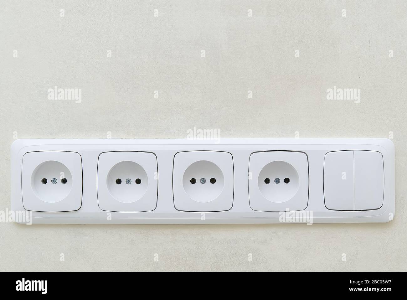 White socket outlets on beige wall. with copy space Stock Photo - Alamy