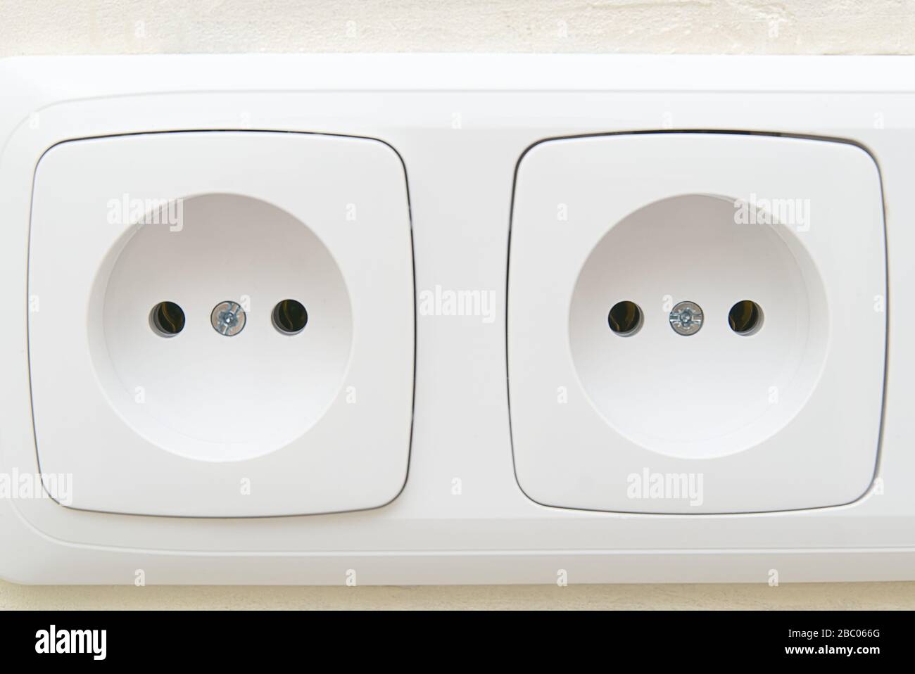 White socket outlets on beige wall. close - up eu standart electric ...