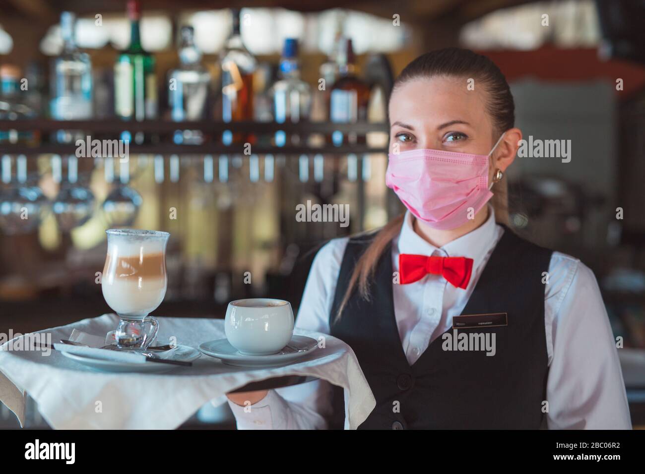 the waiter works in a restaurant in a medical mask Stock Photo - Alamy