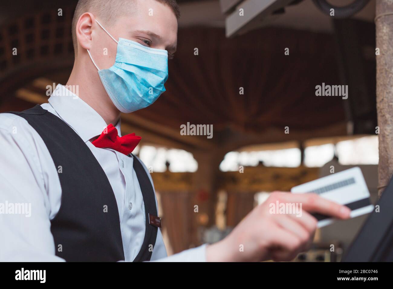 the waiter works in a restaurant in a medical mask Stock Photo - Alamy