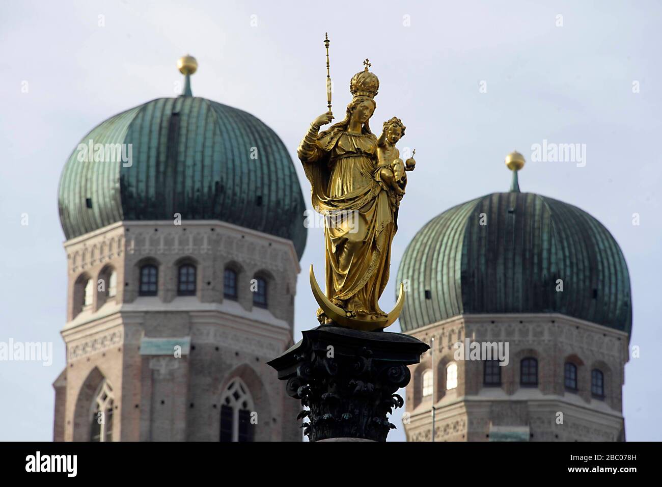 The statue of the Virgin Mary on Munich's Marienplatz with the towers ...