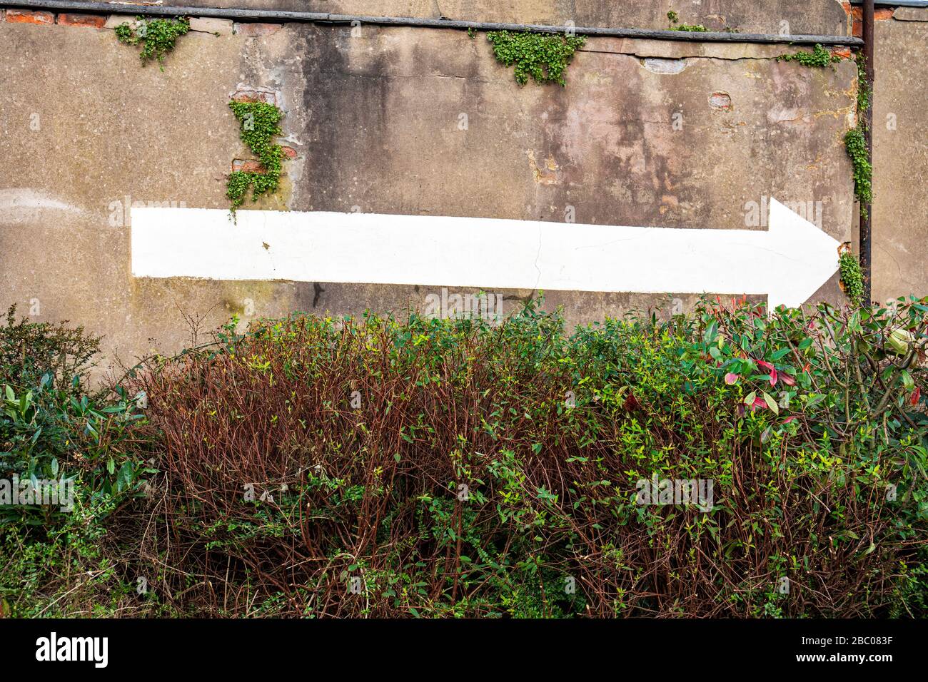 White painted arrow on old wall, showing direction to right Stock Photo ...