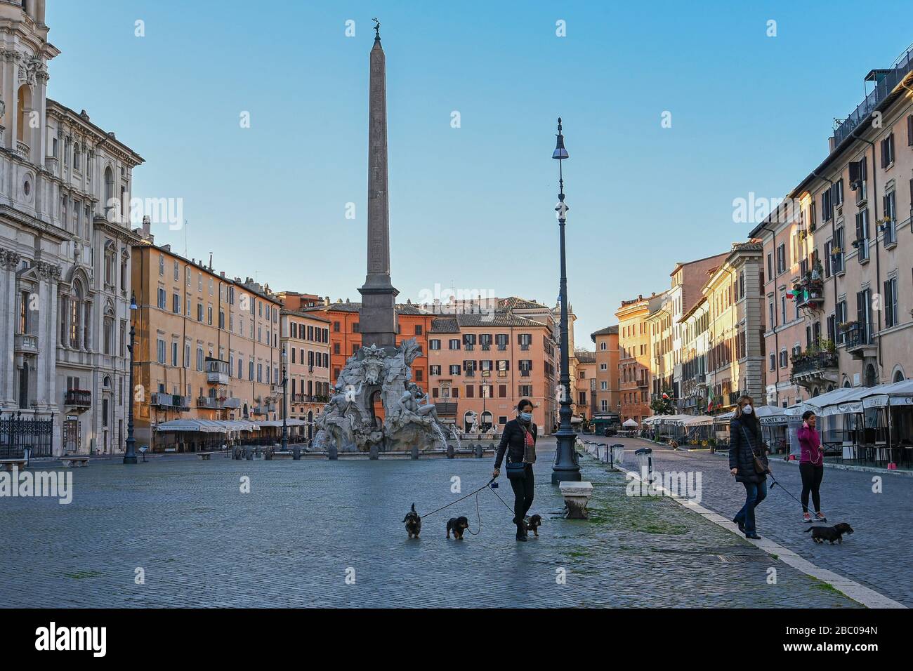 Italy, Rome, 01 April, 2020 : People walk their dog across an empty ...