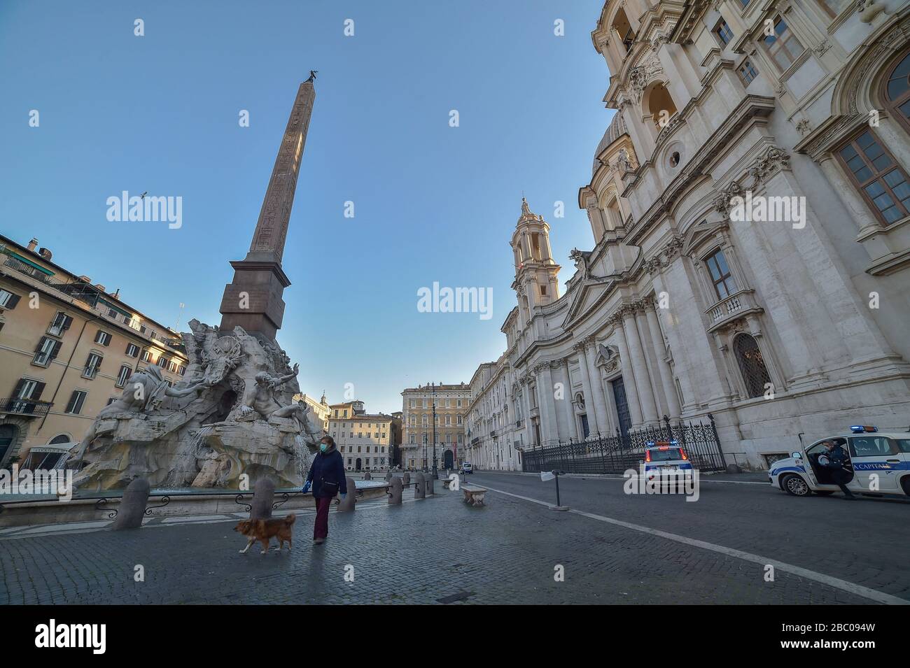 Italy, Rome, 01 April, 2020 : People walk their dog across an empty ...