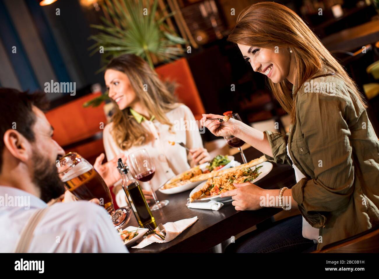 Group of young people having dinner in the restaurant Stock Photo - Alamy