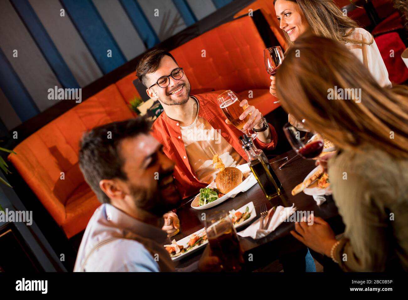 Group of young people having dinner in the restaurant Stock Photo - Alamy