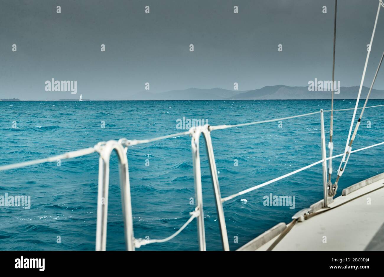 The view of the sea and mountains from the sailboat, edge of a board of ...