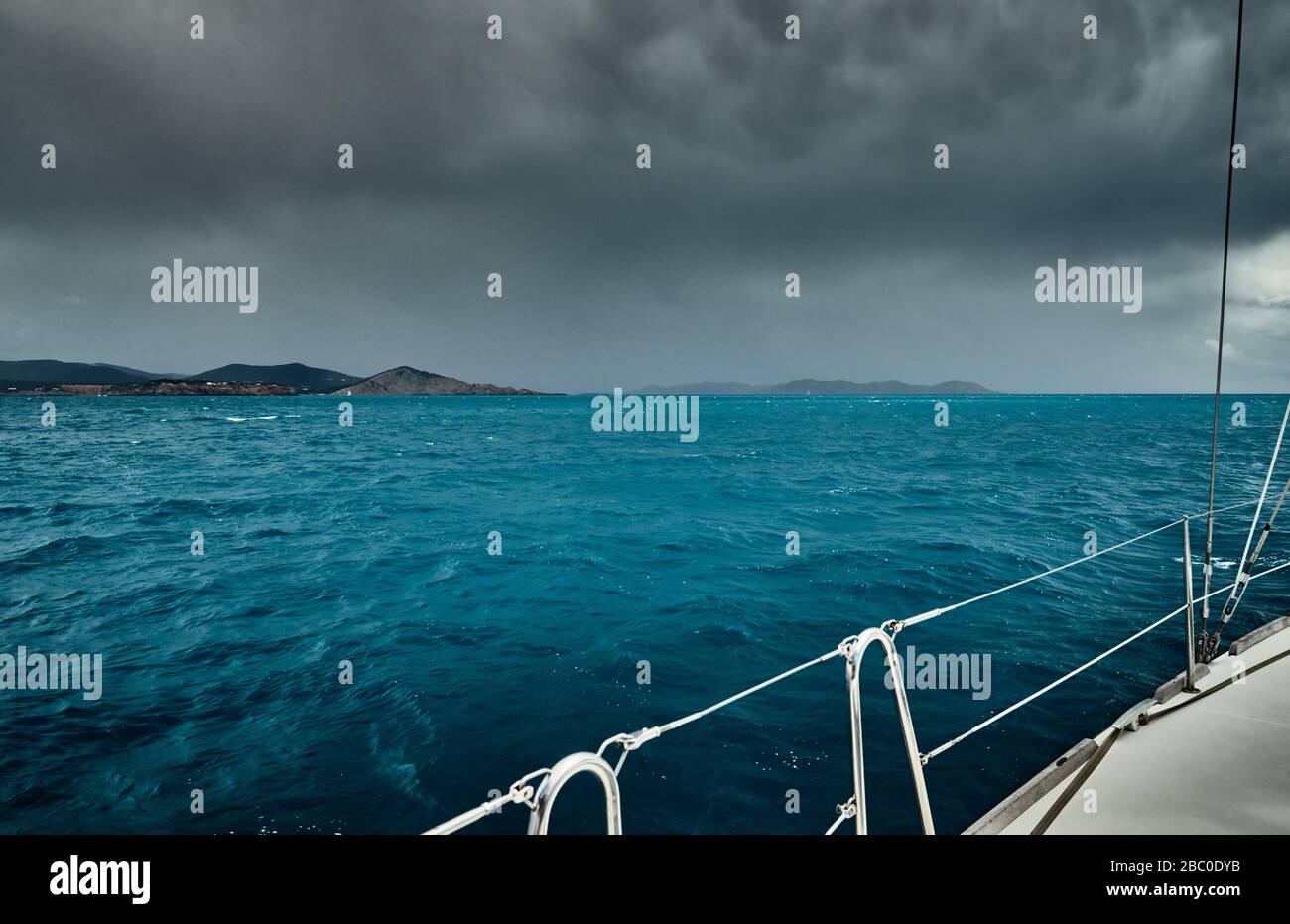 The view of the sea and mountains from the sailboat, edge of a board of ...