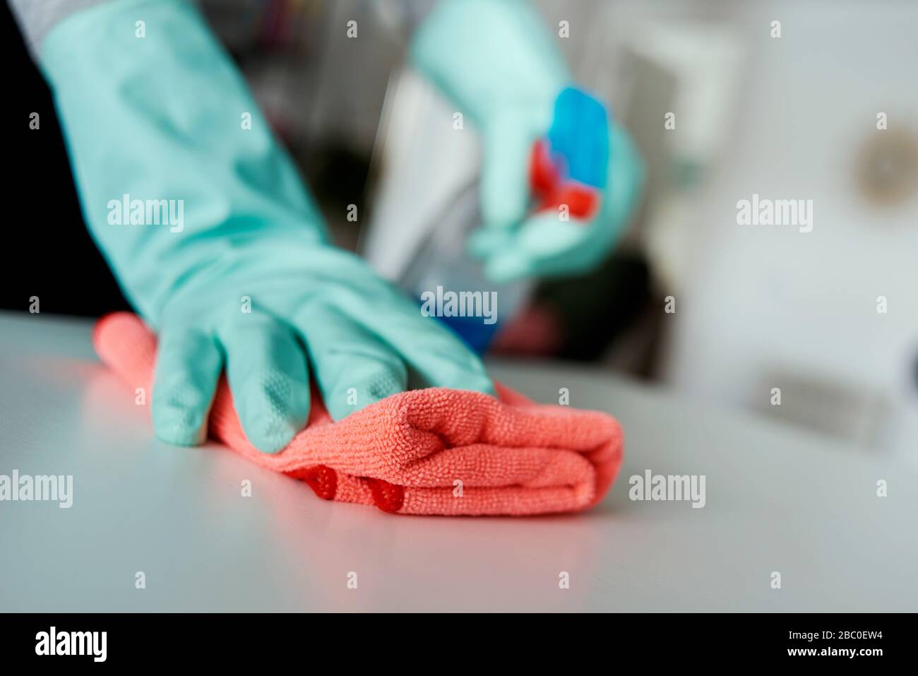 closeup of a man, wearing rubber gloves, cleaning the surface of a ...