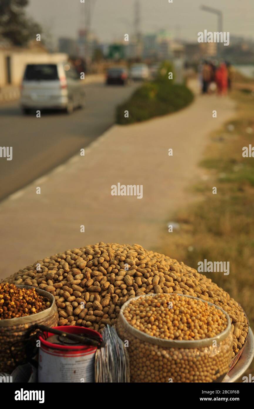 Street peanut vendor waits for customers at Hatirjheel in the capital ...
