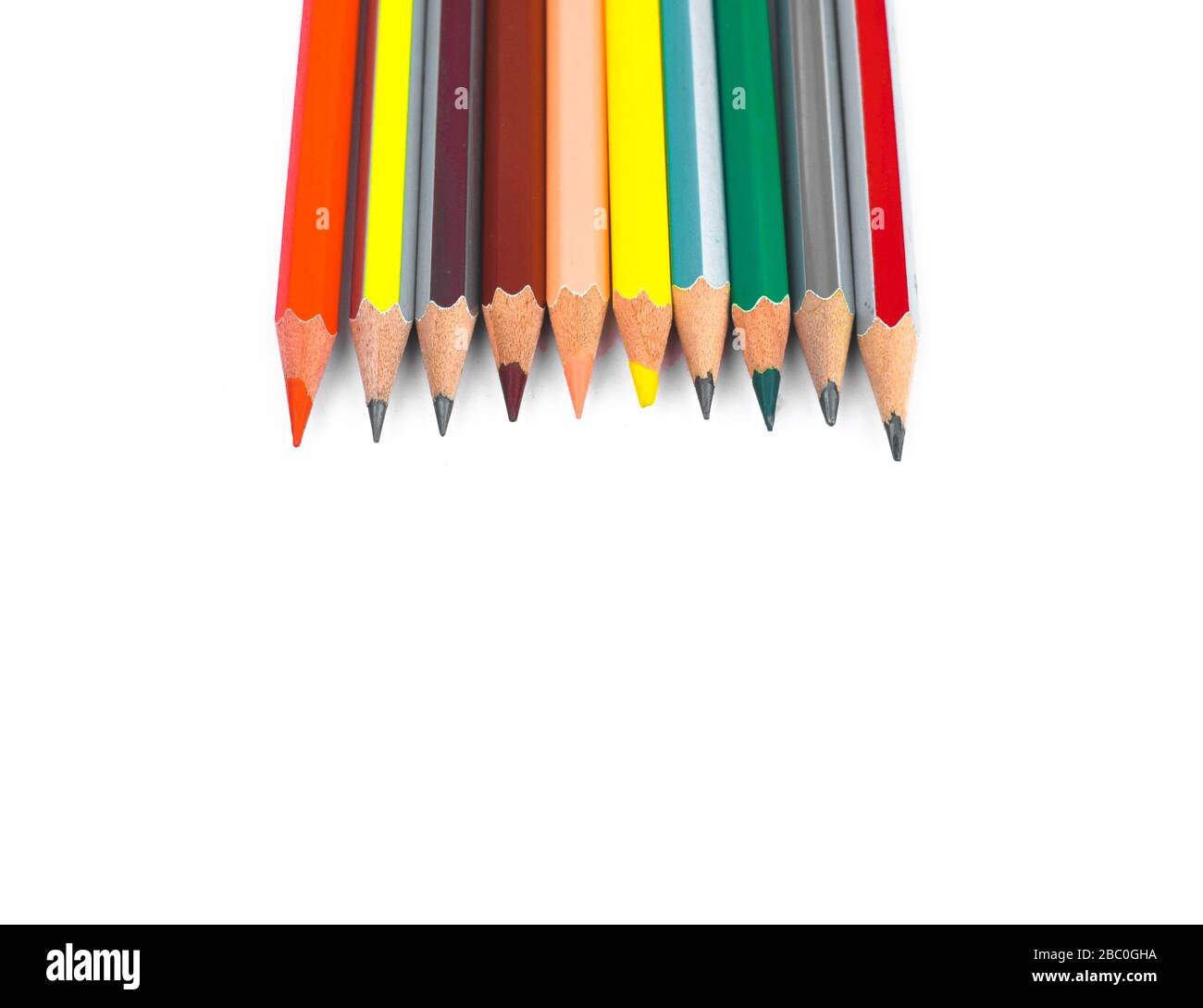 Row of different colored wood pencil crayons arranged together in a ...