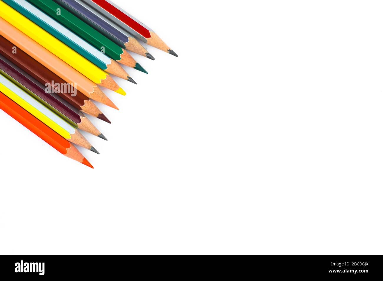 Single row of different colored wood pencil crayons arranged together ...