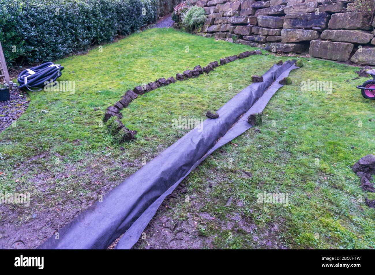 Installing a drainage trench in a garden lawn Stock Photo - Alamy