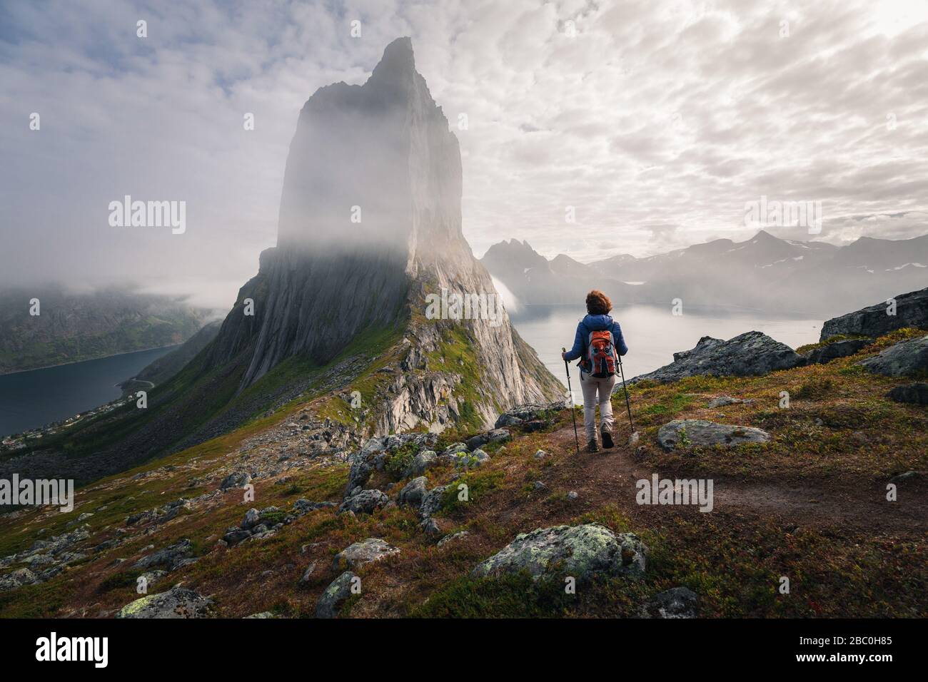 HIKER APPROACHING THE CLIFF FACES OF MOUNT SEGLA PARTIALLY HIDDEN BY ...