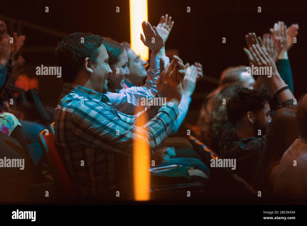 Audience clapping in dark room Stock Photo - Alamy
