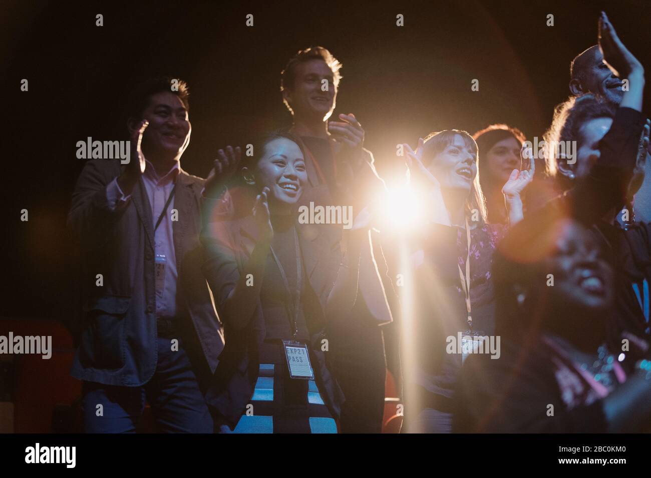 Happy audience clapping in dark room Stock Photo - Alamy