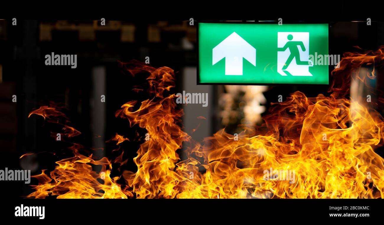 Hot flame fire and green fire escape sign hang on the ceiling in the ...