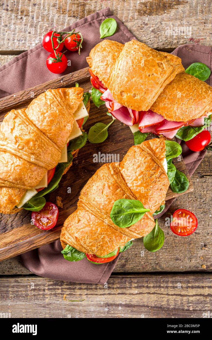 Homemade croissant sandwiches with ham, cheese, fresh vegetables and ...