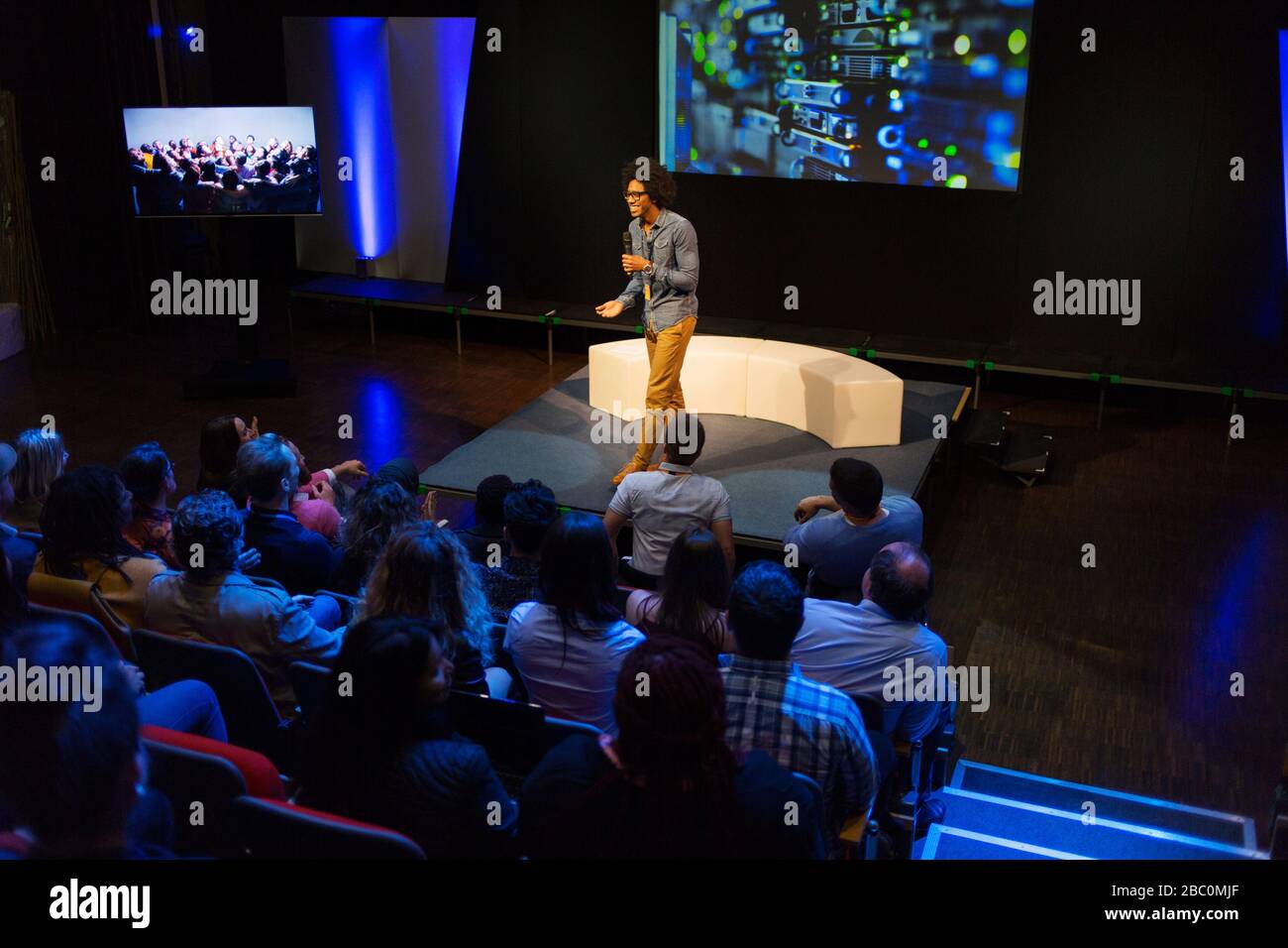 Audience watching male speaker on stage Stock Photo - Alamy