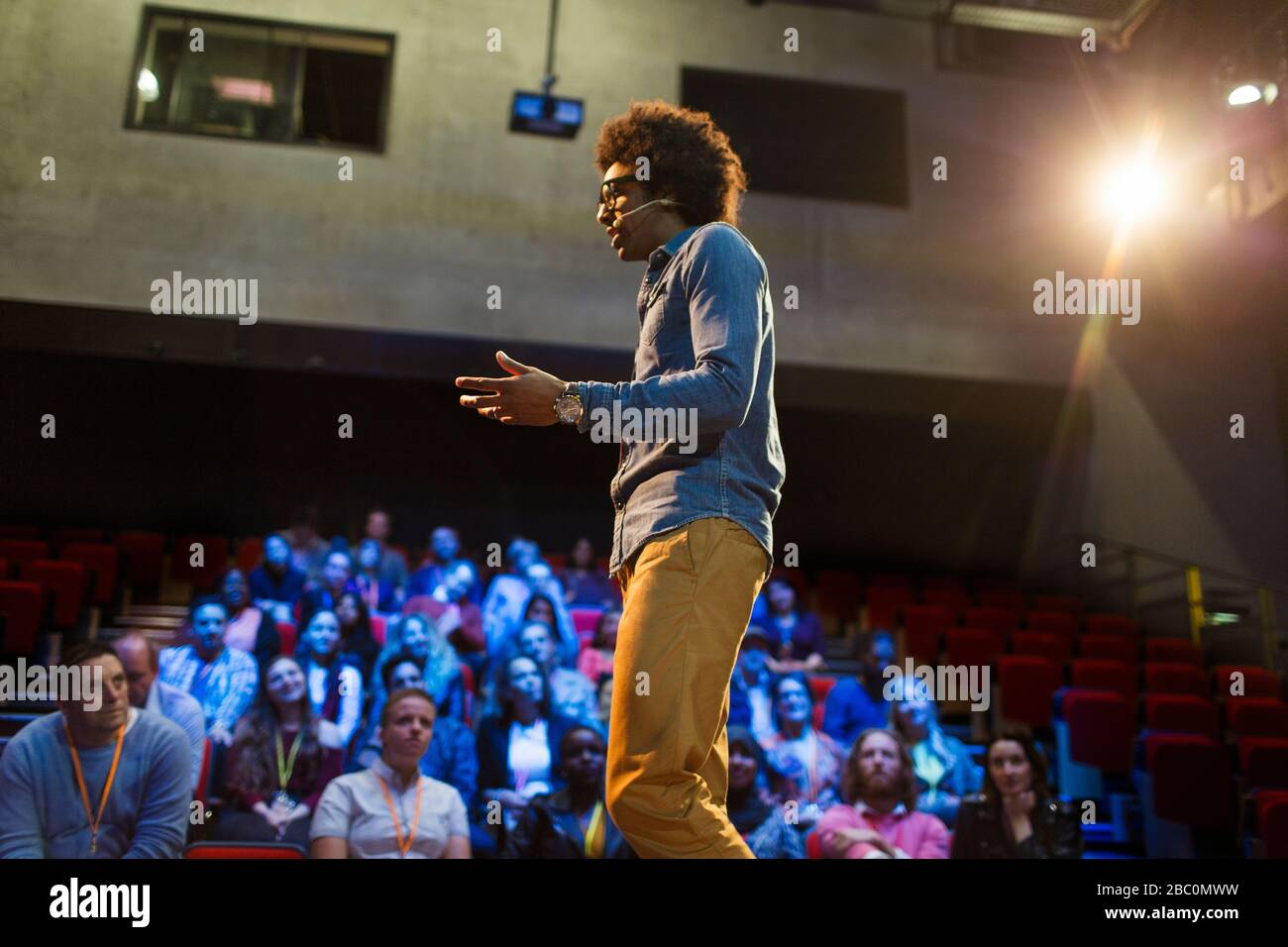 Male speaker on stage talking to audience Stock Photo - Alamy