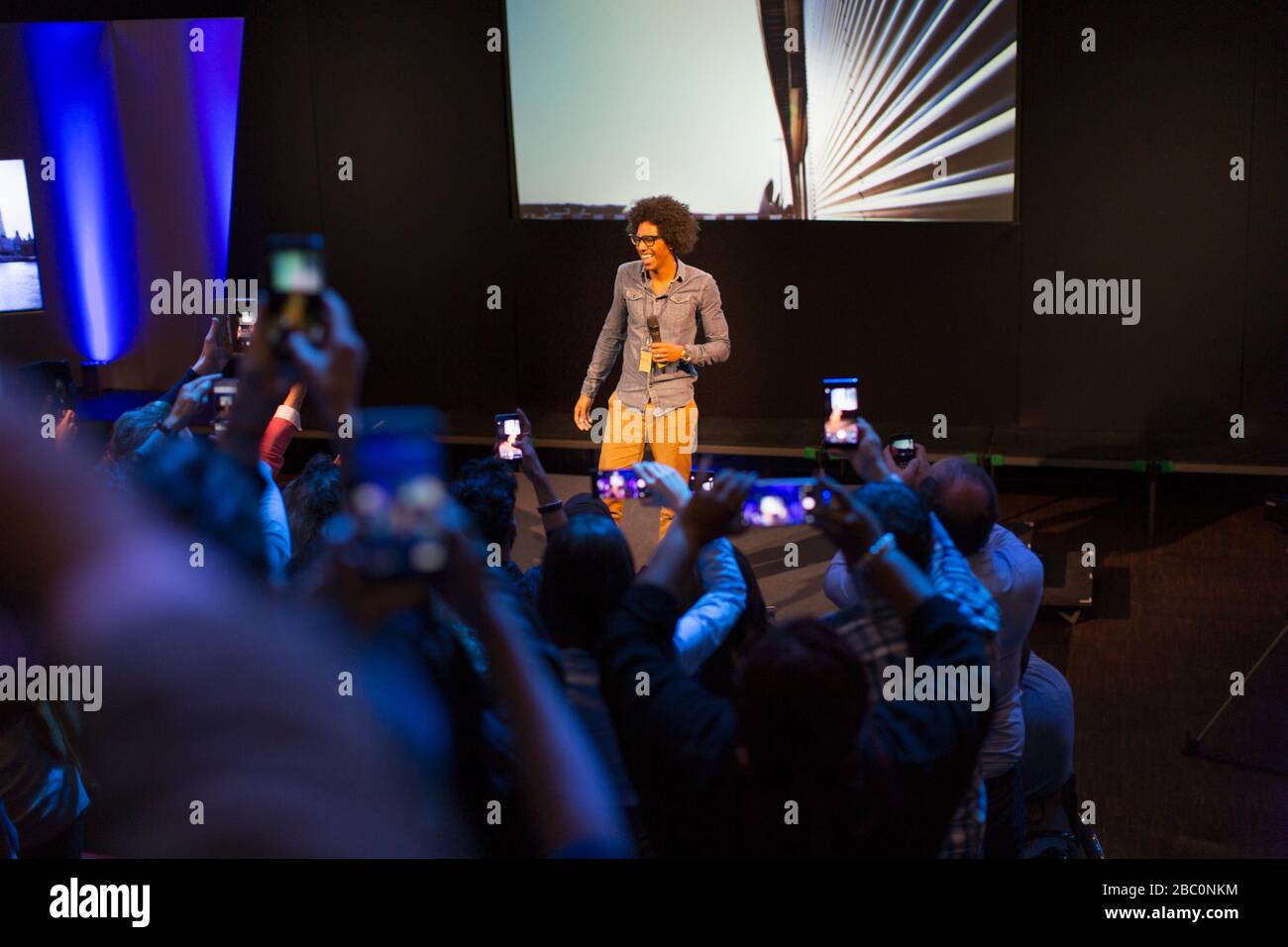 Audience with camera phones photographing speaker on stage Stock Photo ...