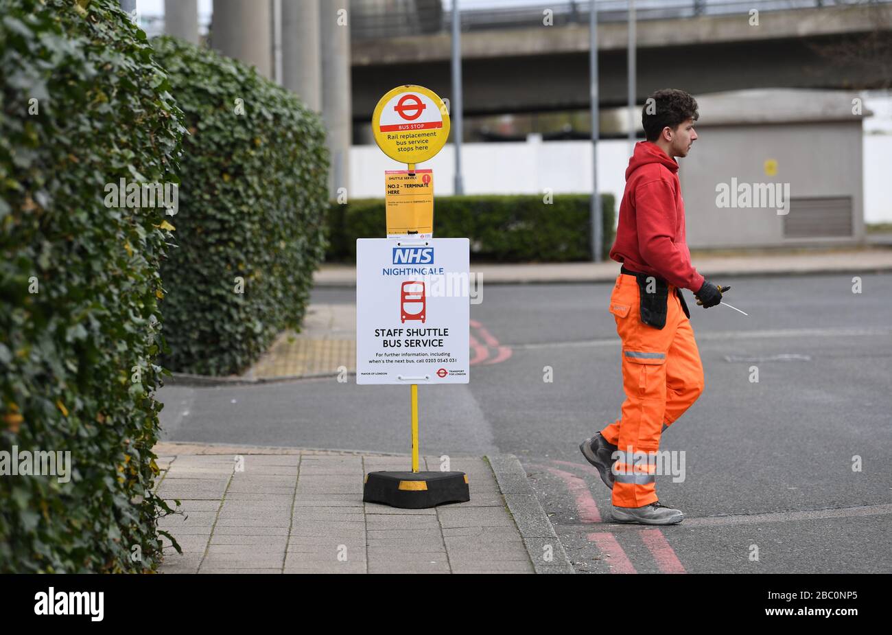 A workman by a stop for the staff shuttle bus service near the ExCel ...