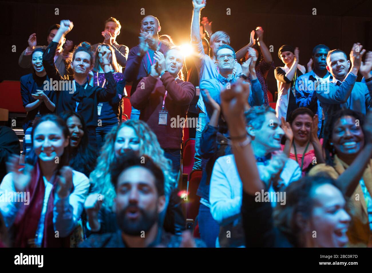 Smiling, excited audience cheering Stock Photo - Alamy