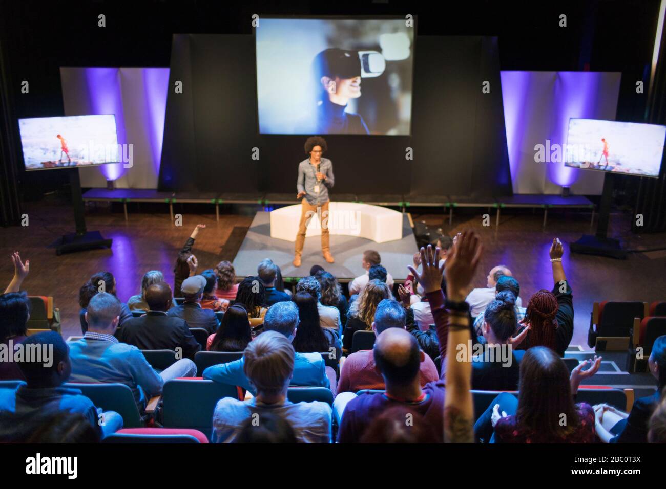 Male speaker on stage answering audience questions Stock Photo - Alamy