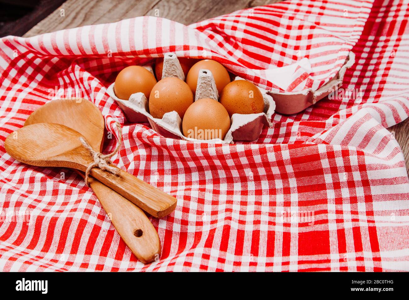 Wooden ladles, garlic and eggs on a red and white table rug Stock Photo ...
