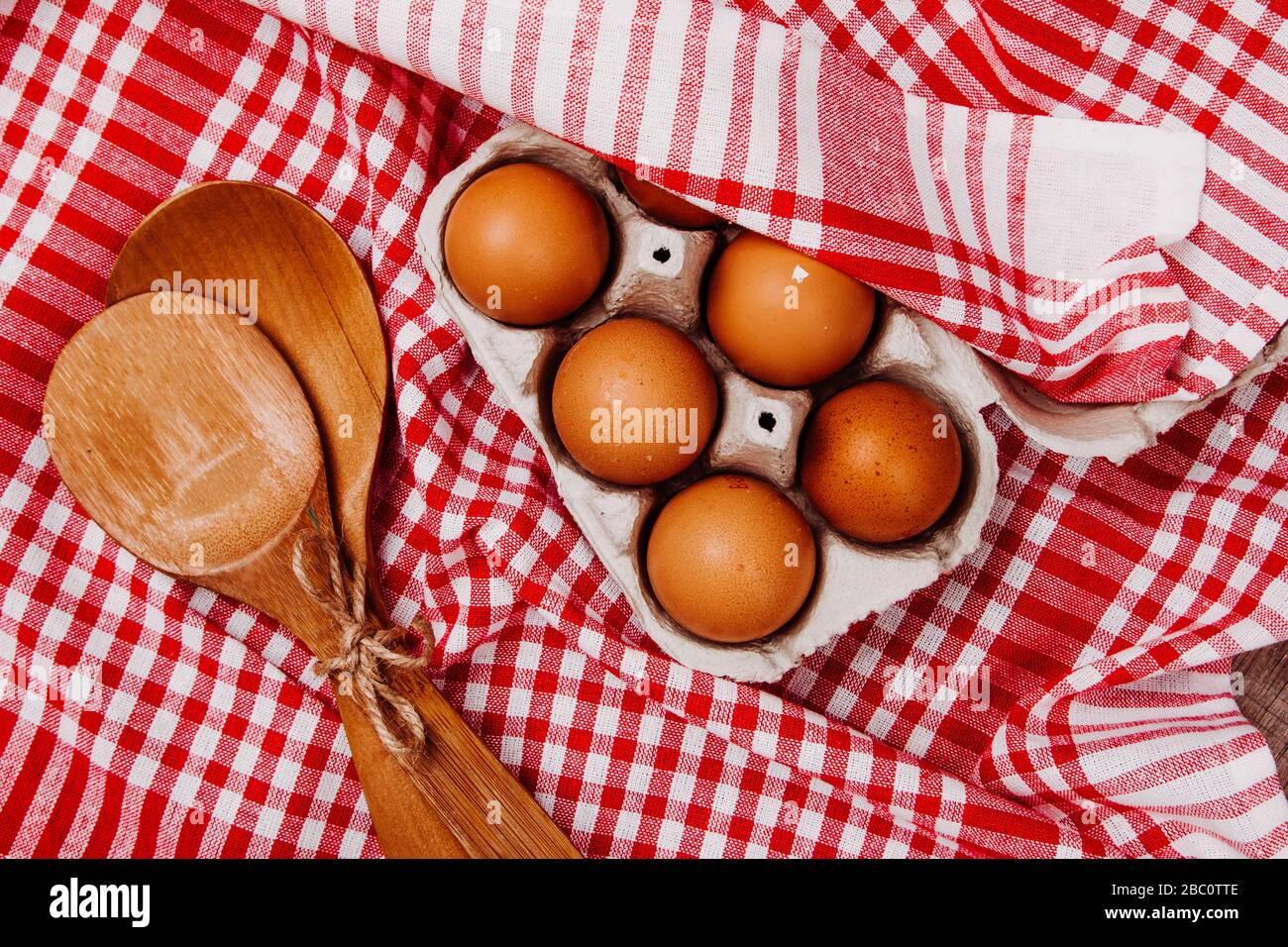 Wooden ladles, garlic and eggs on a red and white table rug Stock Photo ...