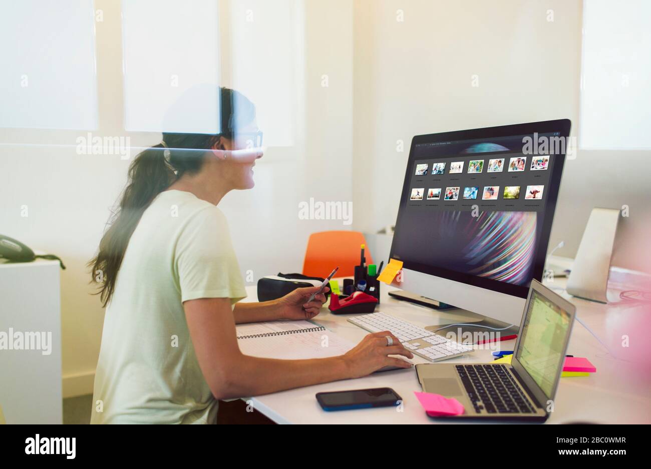 Female designer viewing image thumbnails on computer in office Stock ...