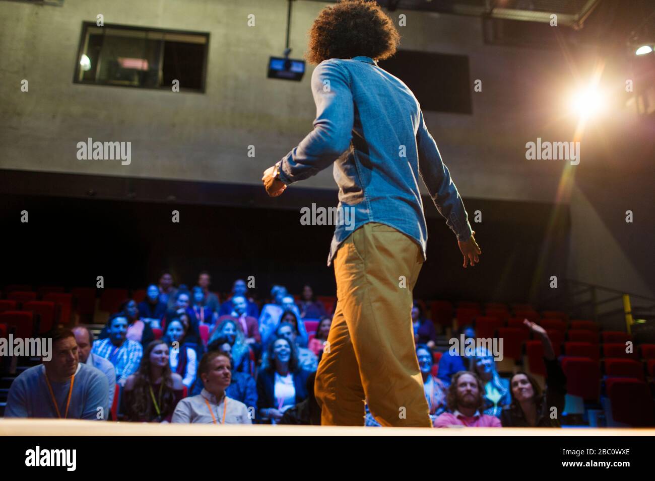 Male speaker on stage talking to audience Stock Photo - Alamy