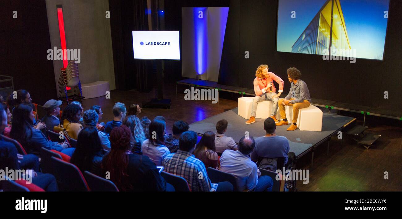 Audience watching speakers talking on stage Stock Photo - Alamy