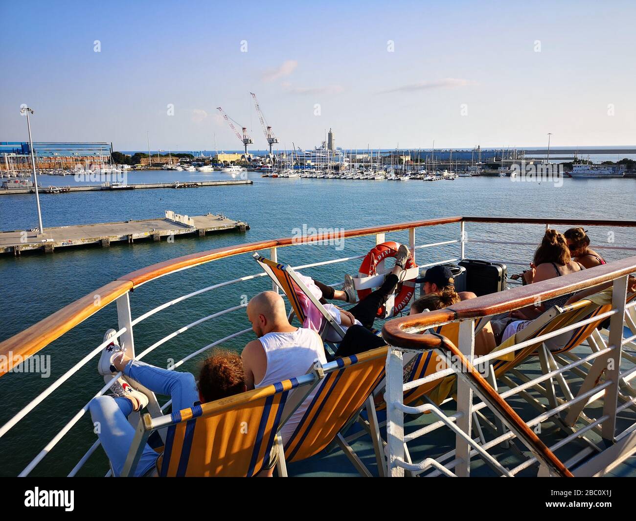 Passengers of a ferry relax on deck chairs while going on holiday Stock ...