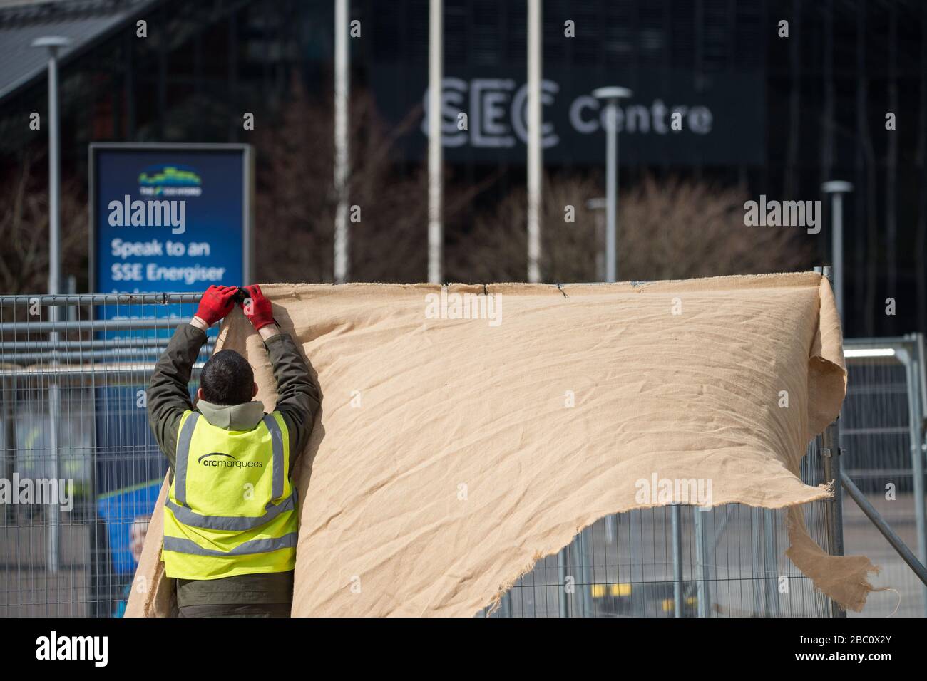 Construction workers puting up privacy screens on security fence hi-res ...