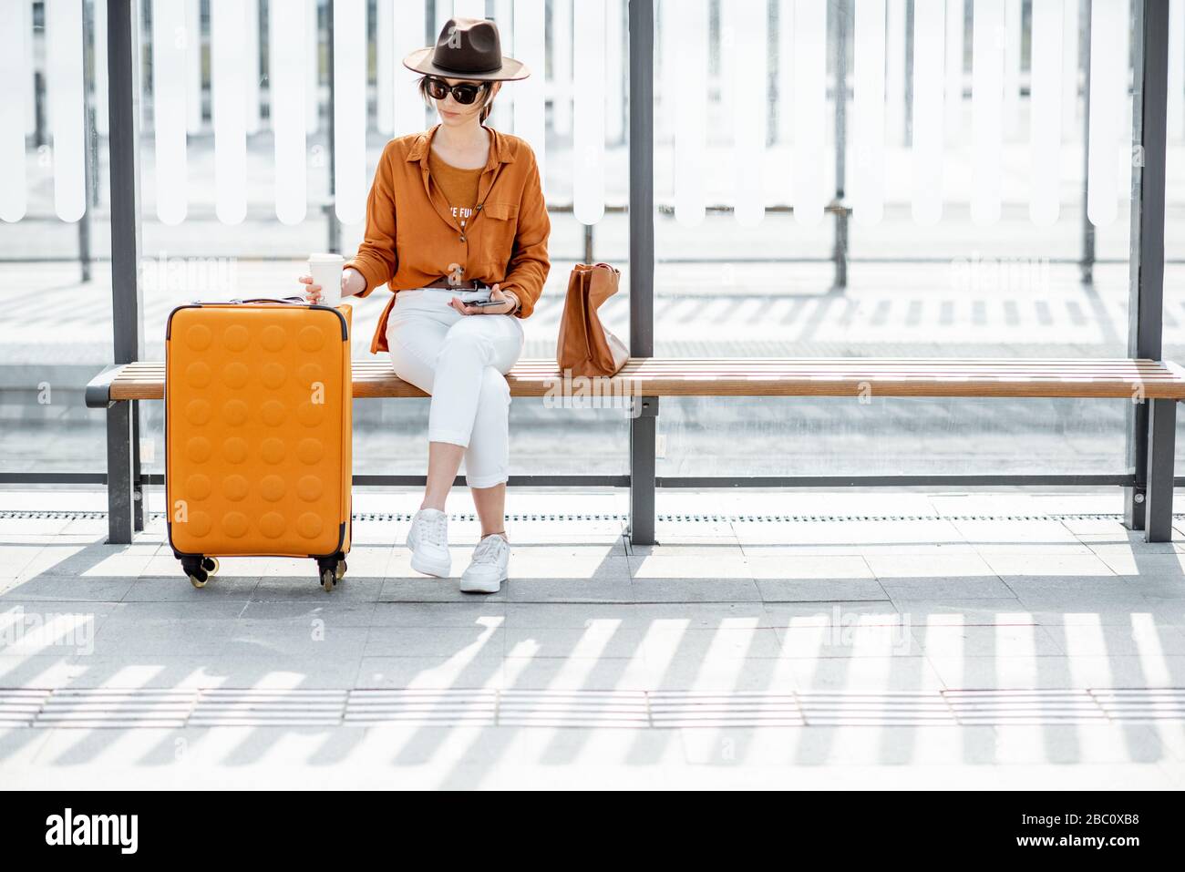 Sitting on bus stop bench hi-res stock photography and images - Alamy