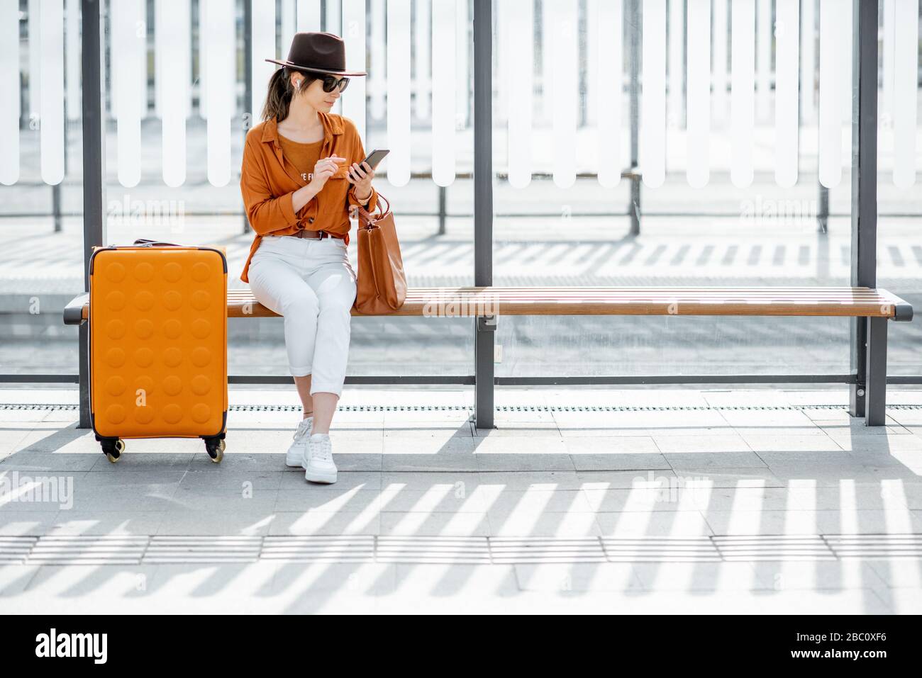 Sitting on bus stop bench hi-res stock photography and images - Alamy