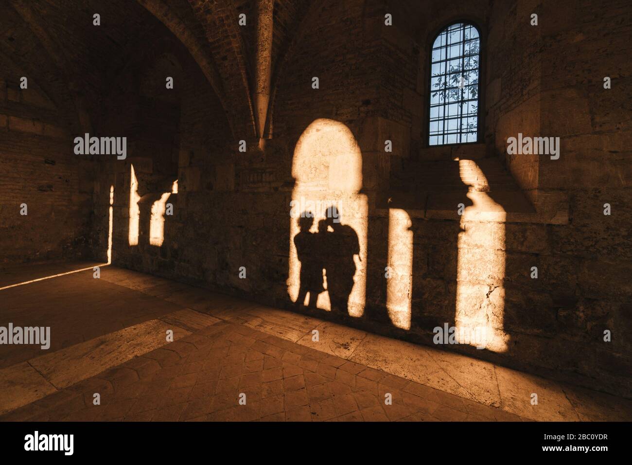 Shadow of parents with small child inside an ancient medieval stone ...