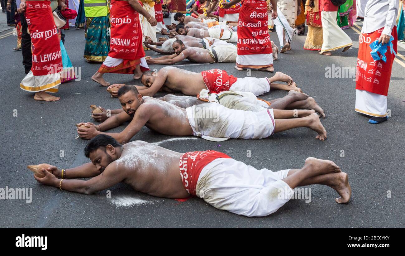 Hindu men roll on the ground in worship and as an offering to the deity ...