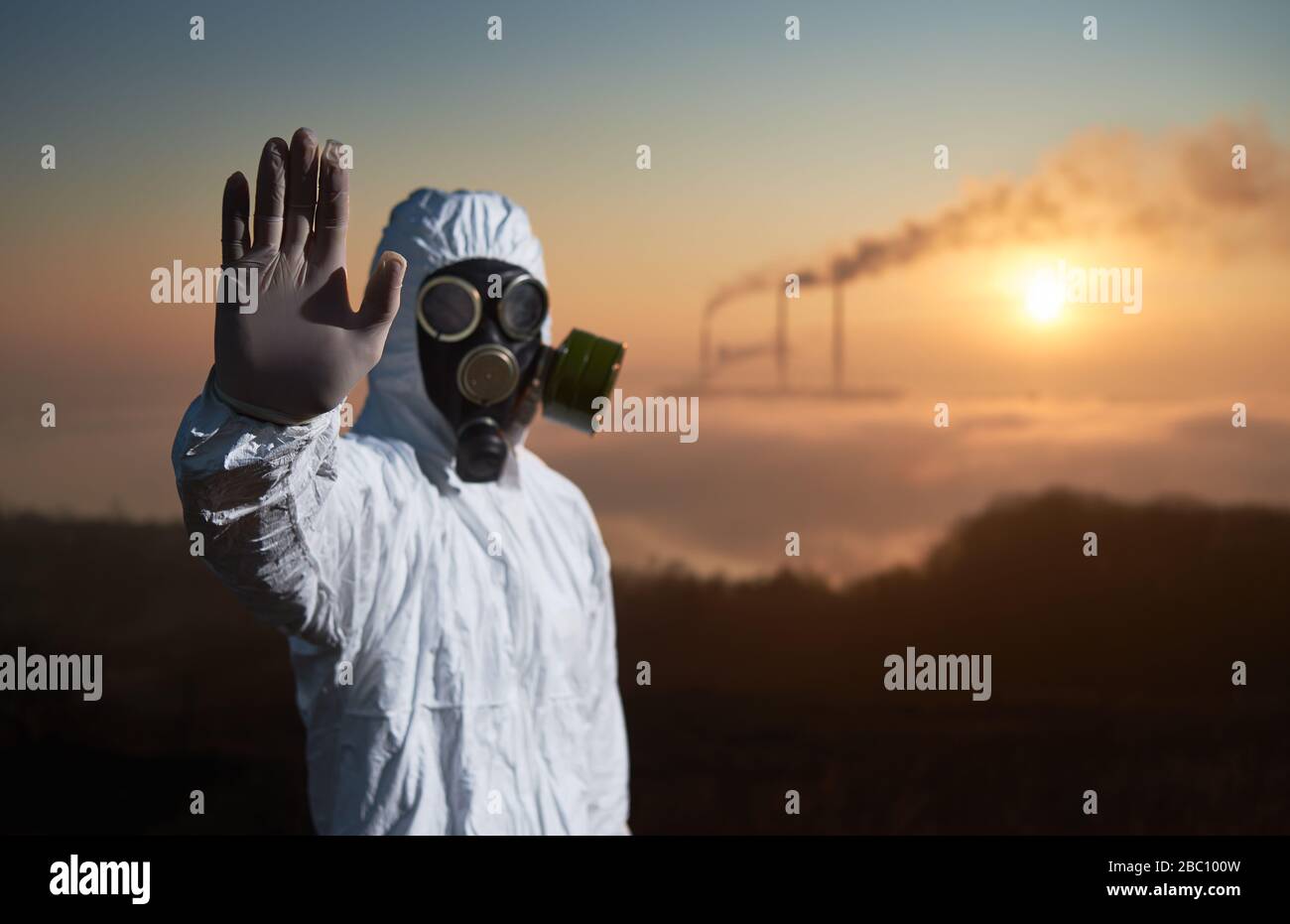 Portrait of a scientist wearing white protective uniform and gas mask ...
