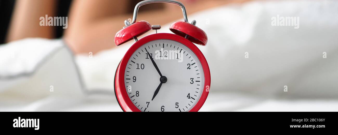 Red old fashioned alarm clock set at seven in morning Stock Photo - Alamy