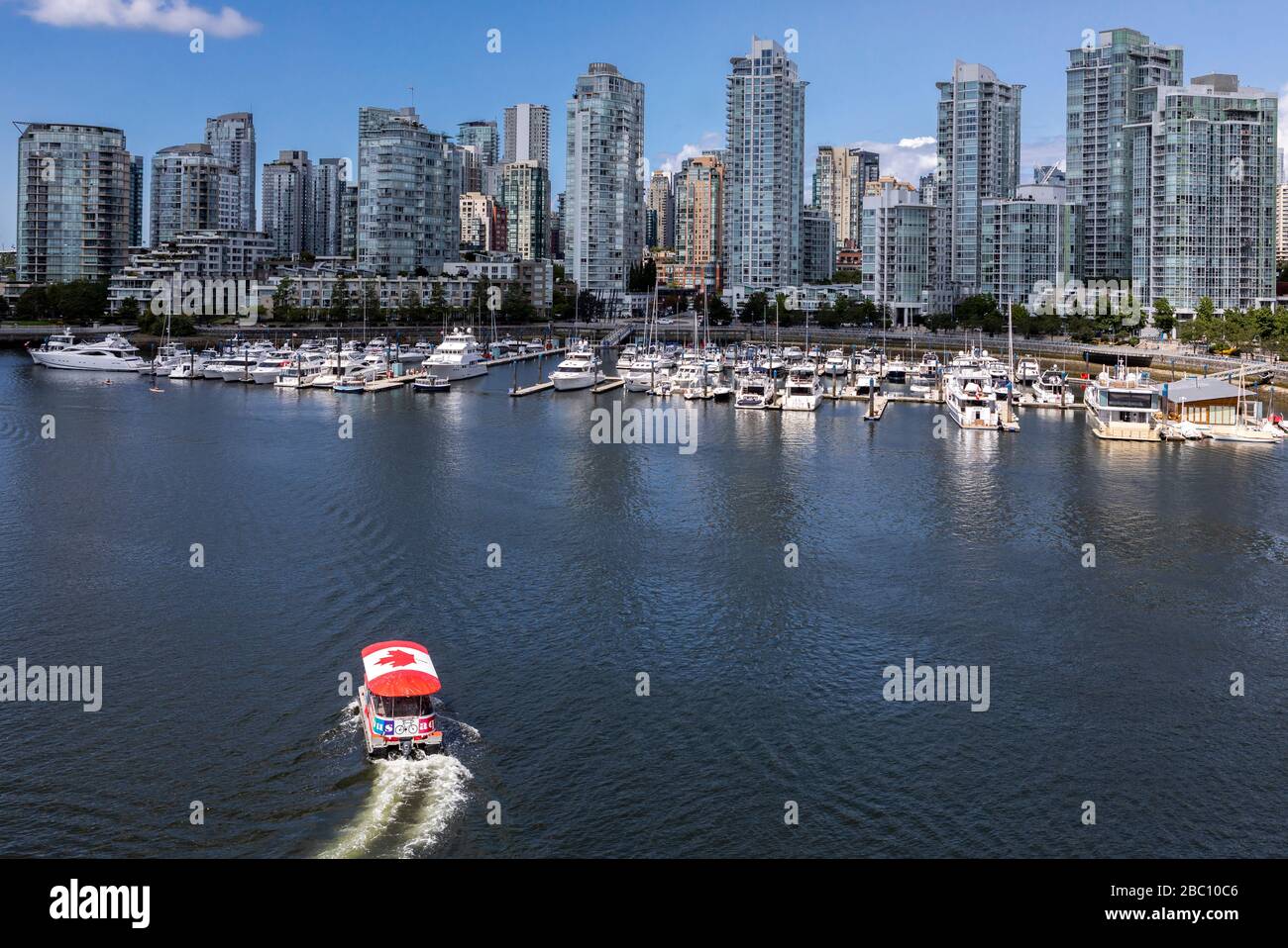 Coal Harbour with small ferry adorned with Maple Leaf flag, Vancouver ...