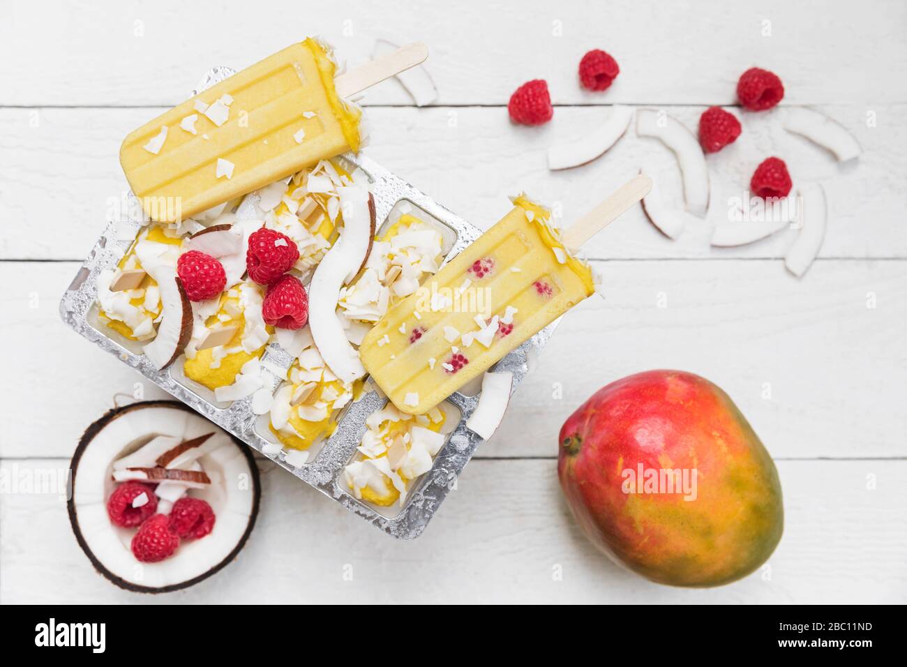 Homemade mango and raspberry popsicles with coconut chips Stock Photo ...