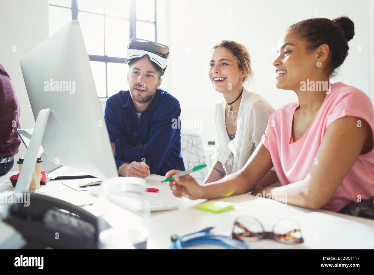 Computer programmers programming virtual reality simulator glasses at computer in office Stock ...