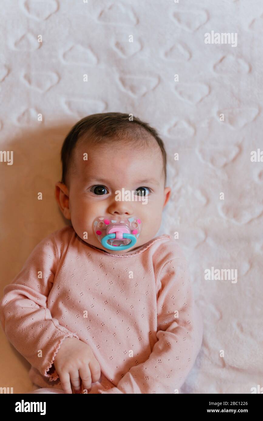 Portrait of a baby girl sucking a pacifier hi-res stock photography and ...