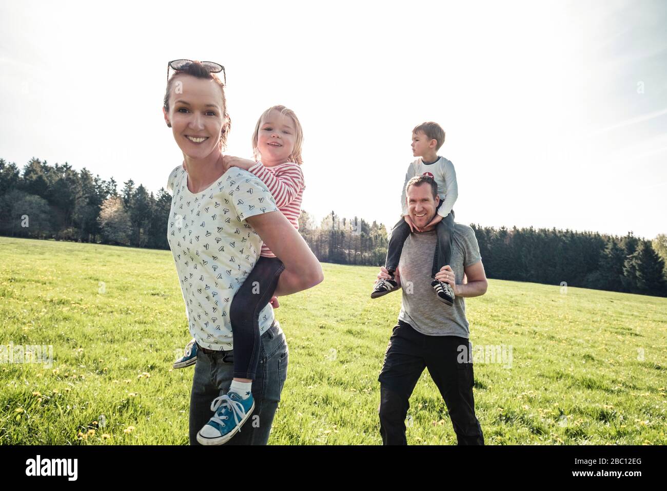 Happy family with two kids on a meadow in spring Stock Photo - Alamy