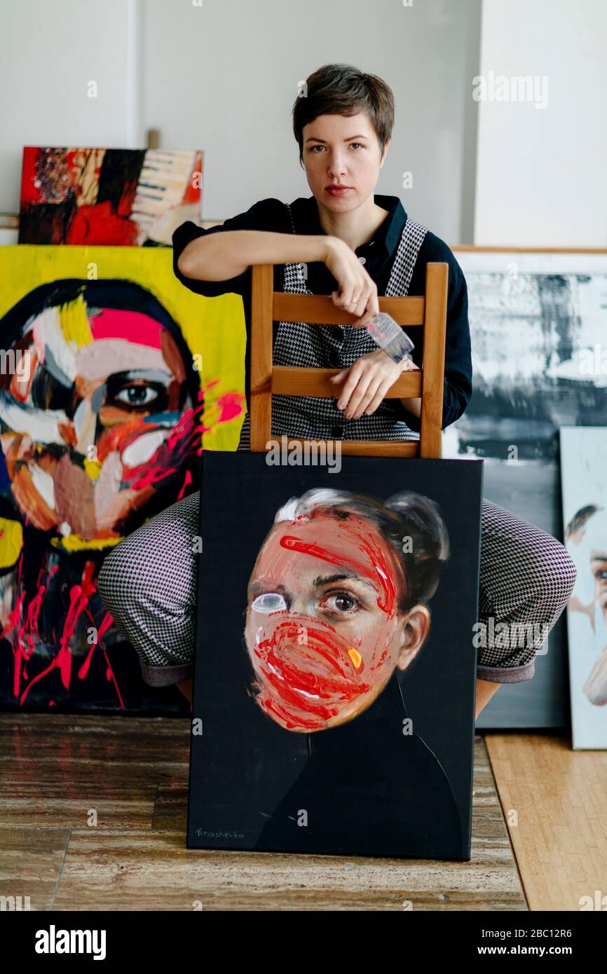 Portrait of a female painter sitting on a chair in her studio Stock ...