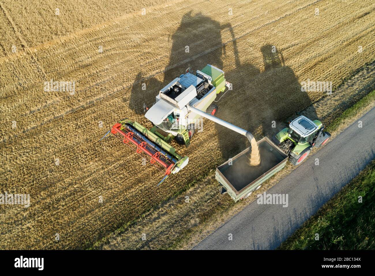 Combine Harvester unloading grain to trailer on tractor. Franconia ...